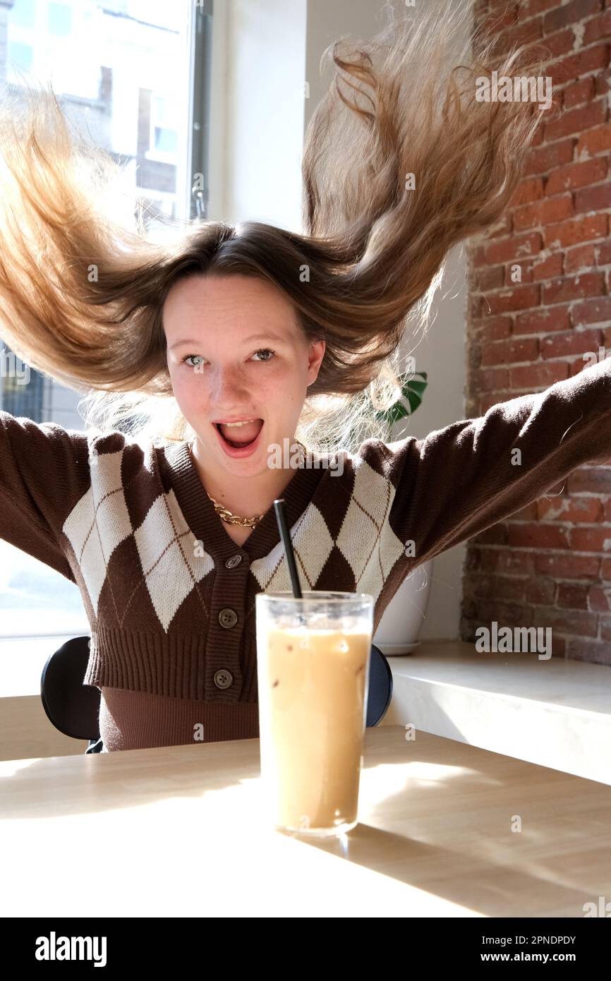 girl throws up her hair laughs with her mouth open spread in her arms ...