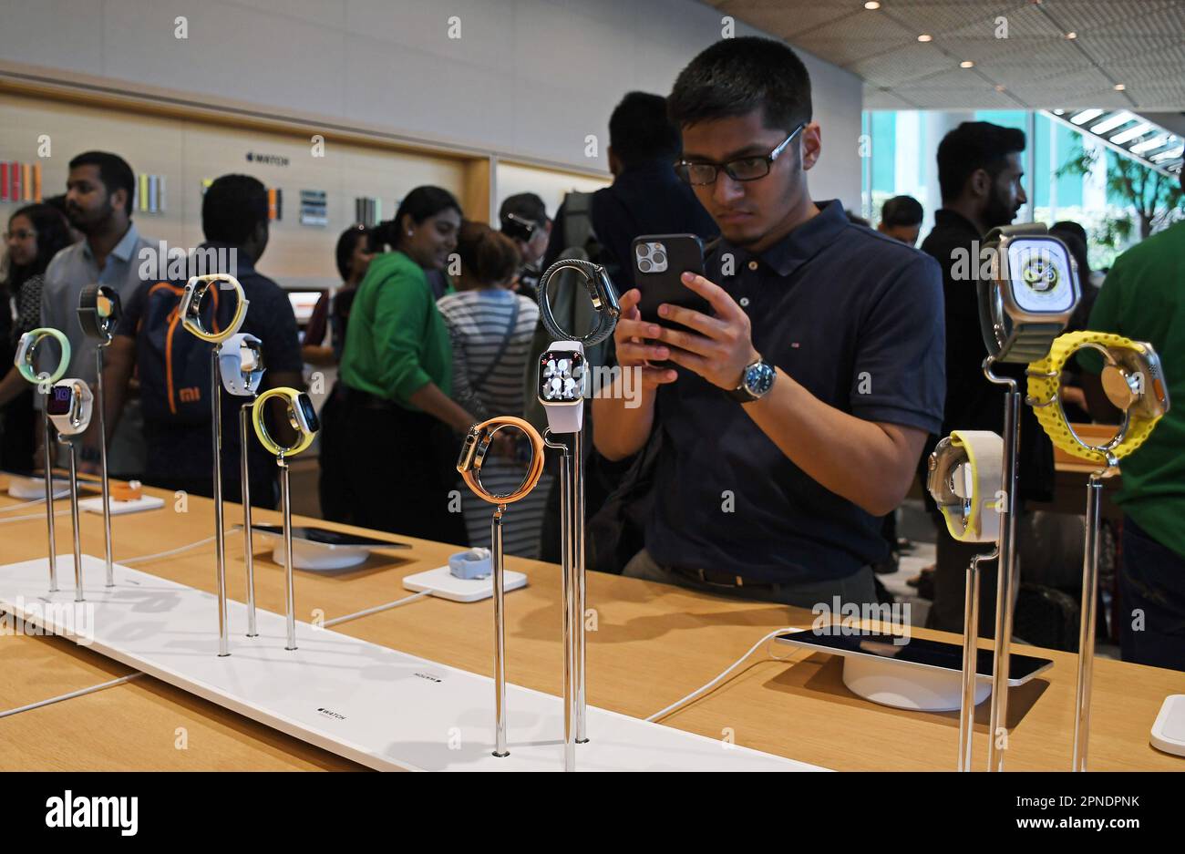 Mumbai, India. 18th Apr, 2023. A man takes photos of Apple's smart ...