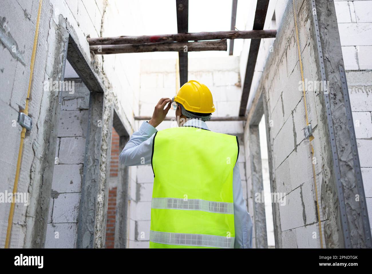 Concentrated engineer in safety vest at construction site wearing a ...