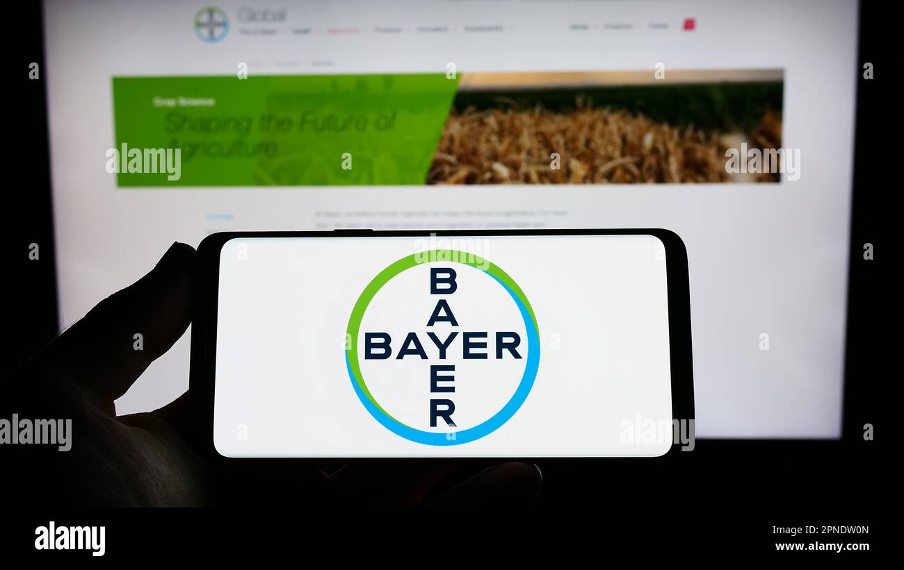 Person holding smartphone with logo of German pharmaceutical company ...