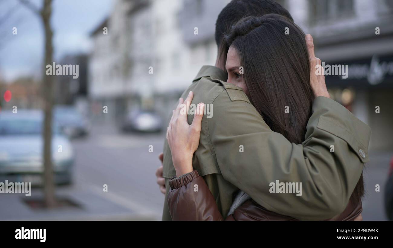 Couple embrace standing in street in empathic hug. Caring and ...