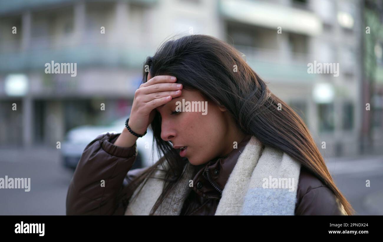 One anxious young woman suffering from mental pain standing outside in ...