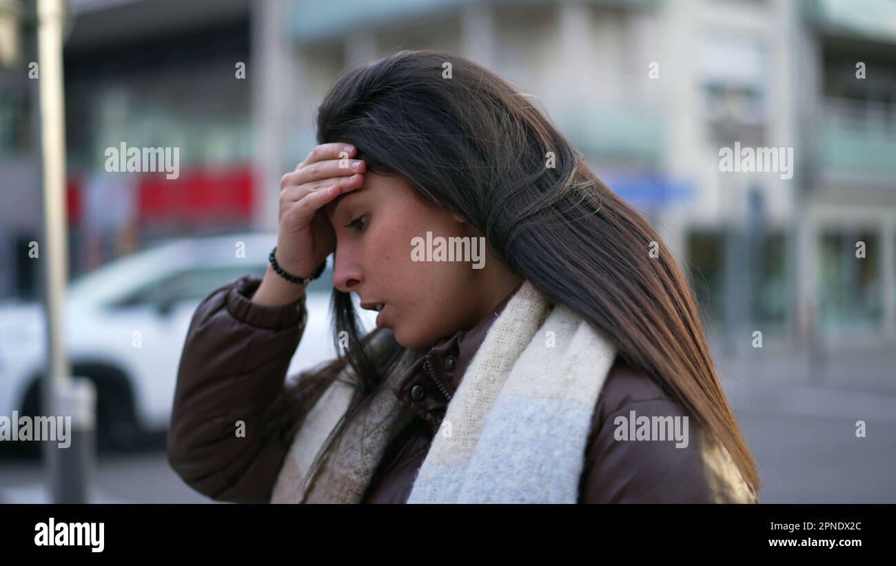 One anxious young woman suffering from mental pain standing outside in ...