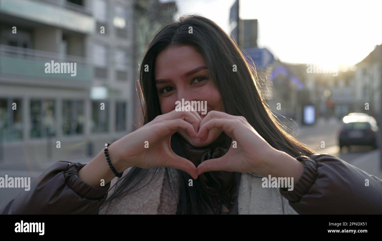Love young woman makes symbol hi-res stock photography and images - Alamy