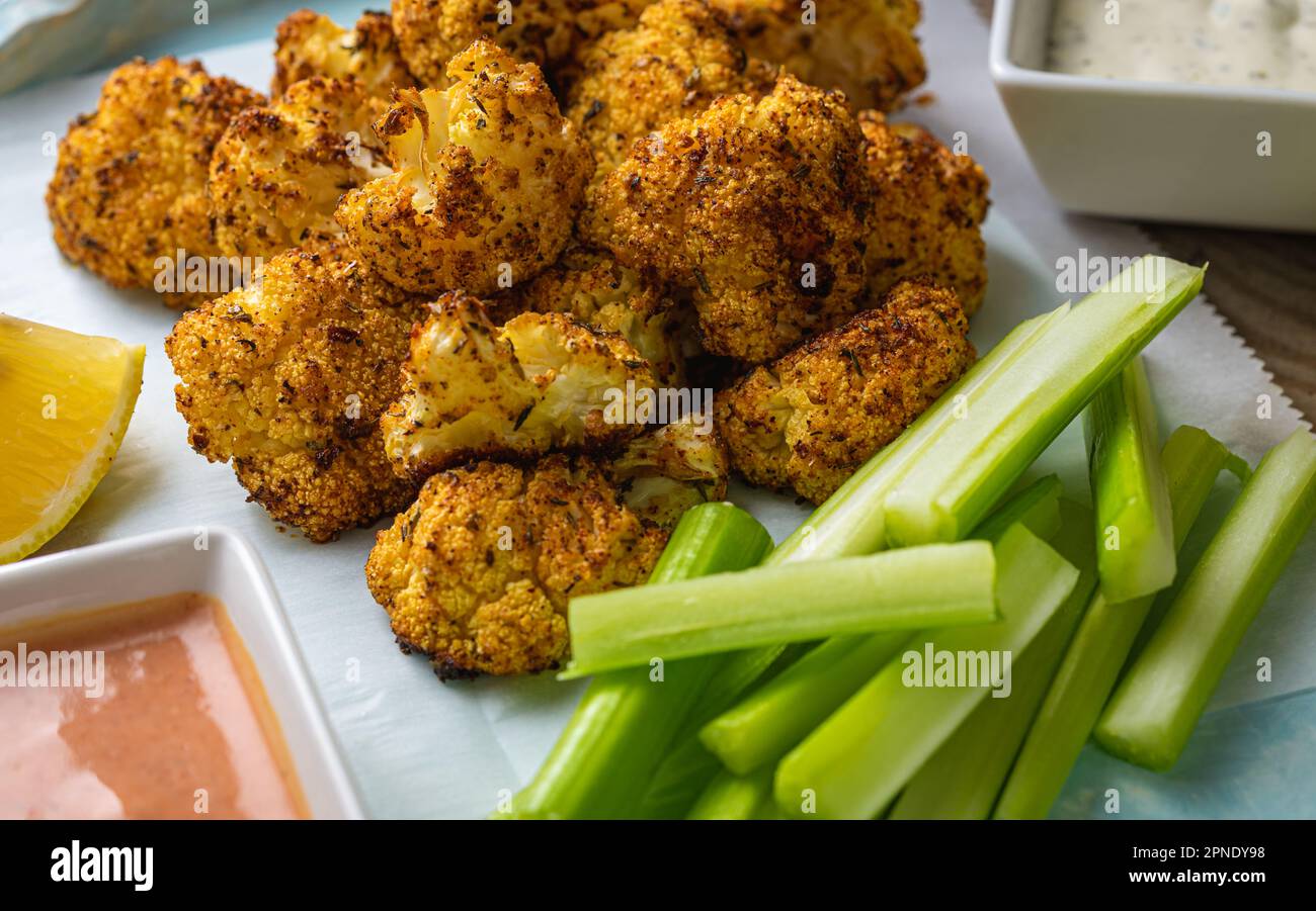 Vegan Buffalo cauliflower with celery sticks. Above, close up shot ...