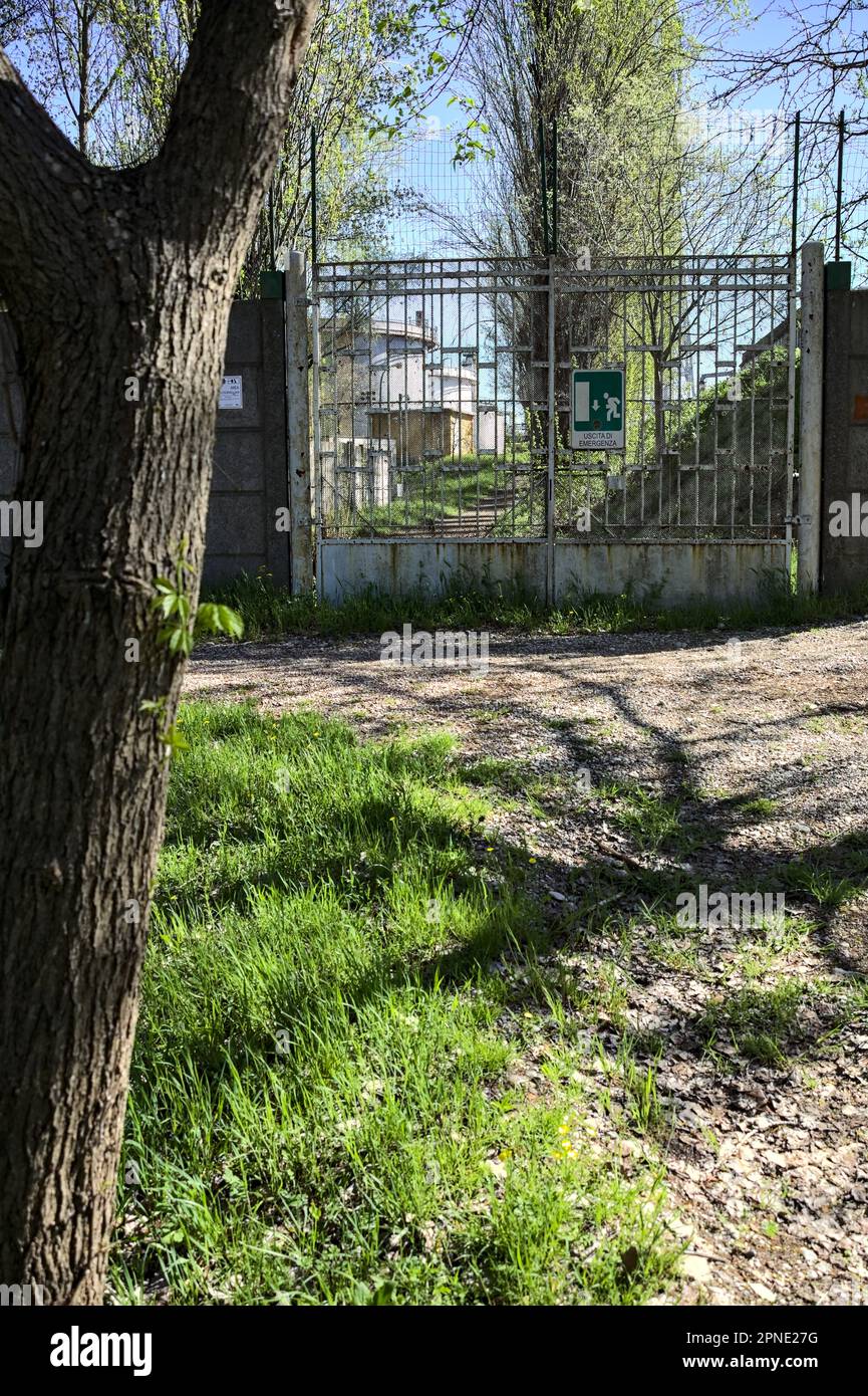 Gate in a concrete boundary wall of a factory by the edge of a path in ...