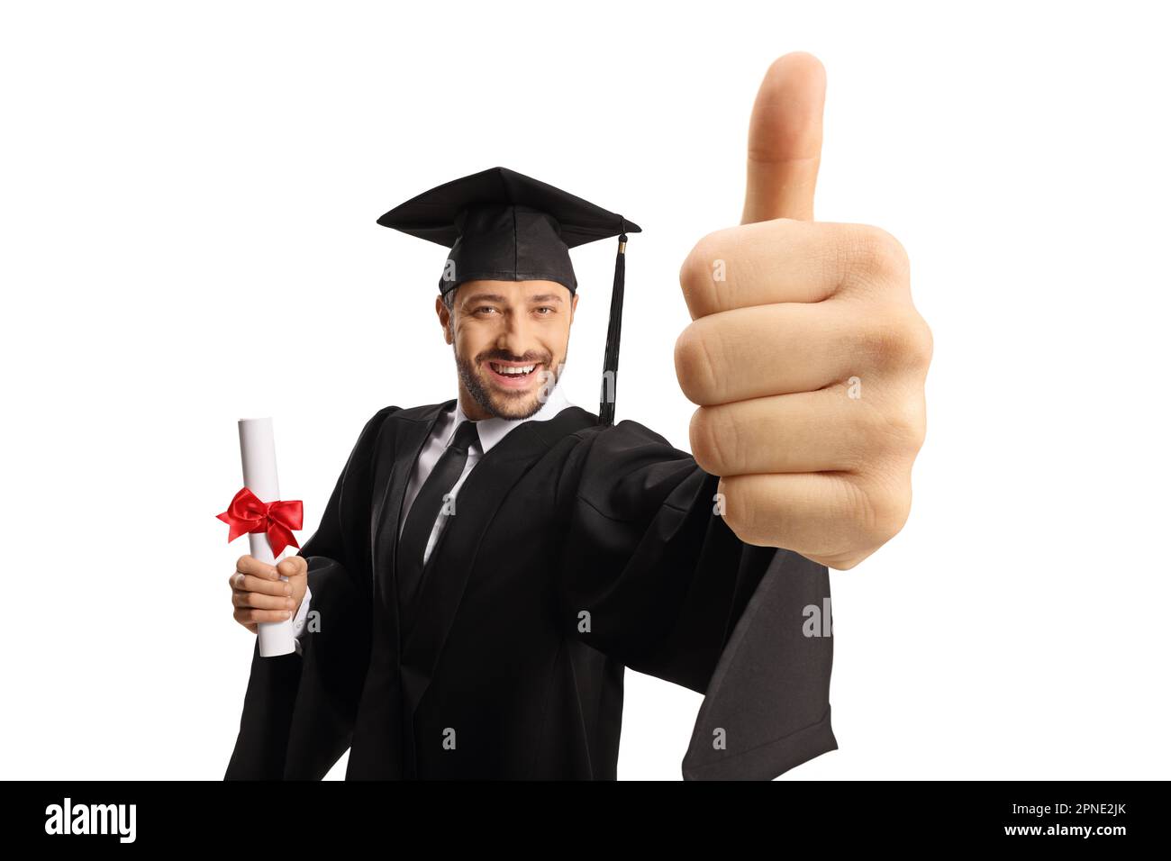 Man in a graduation gown holding a diploma and showing thumbs up ...