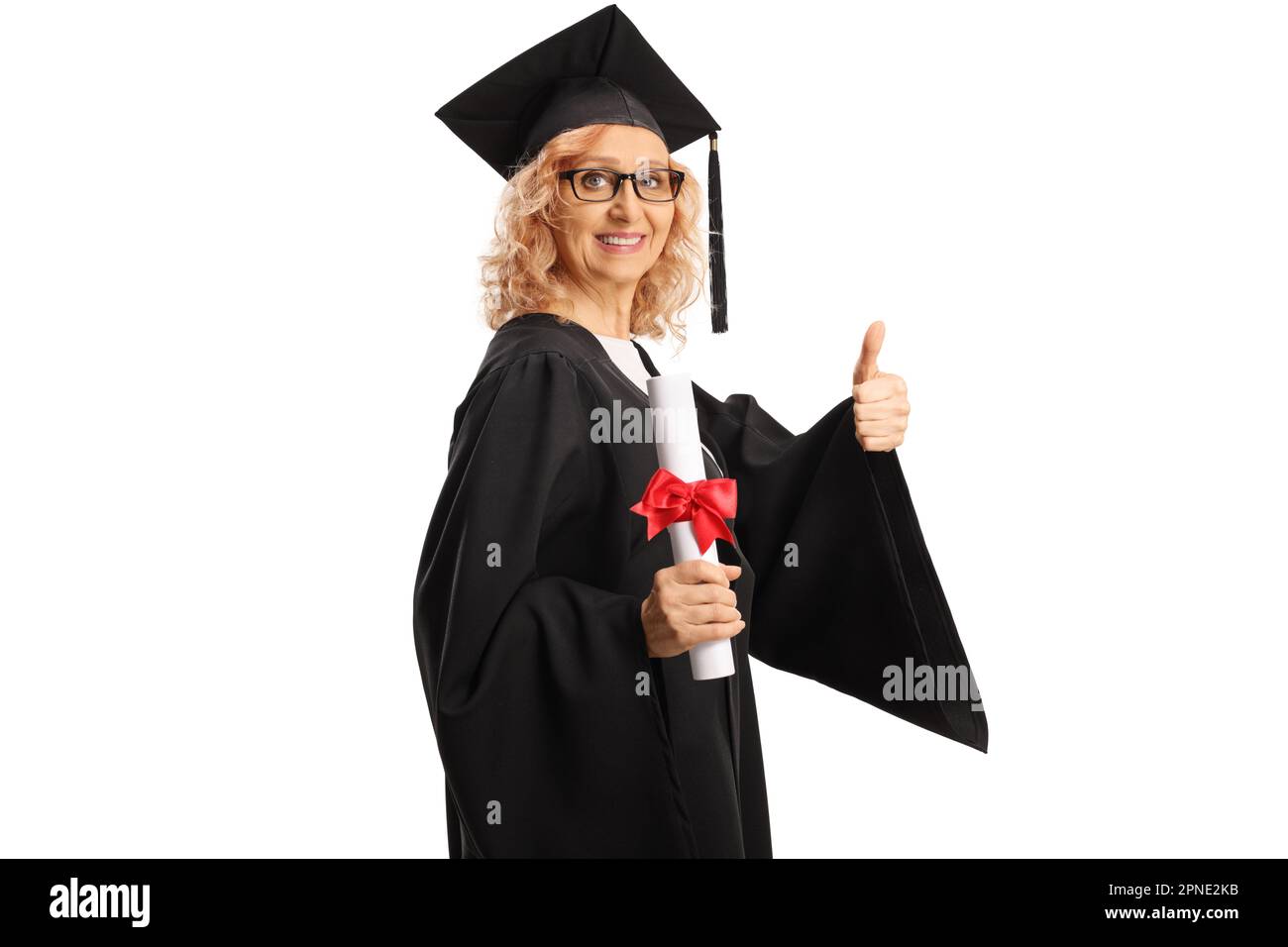 Mature woman in a graduation gown holding a diploma and showing thumbs ...