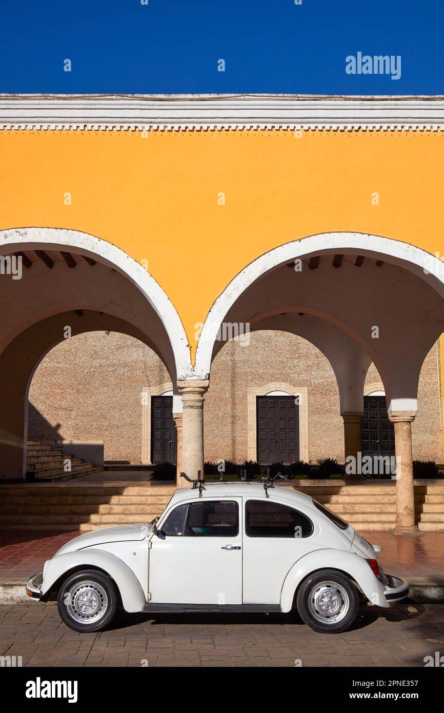 A vintage Volkswagen Beetle in front of the Municipality of Izamal ...