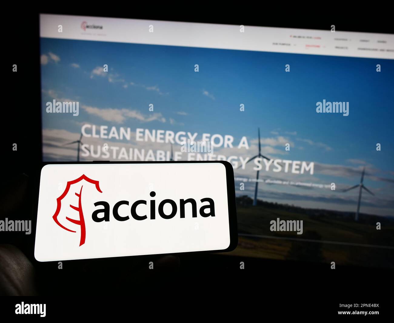 Person holding cellphone with logo of Spanish infrastructure company ...