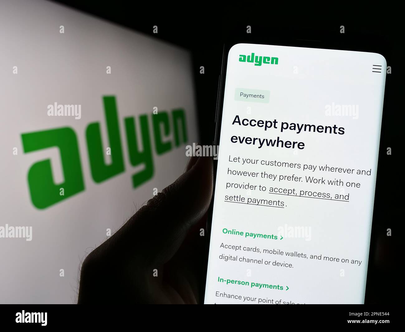 Person holding cellphone with webpage of Dutch payments company Adyen N ...