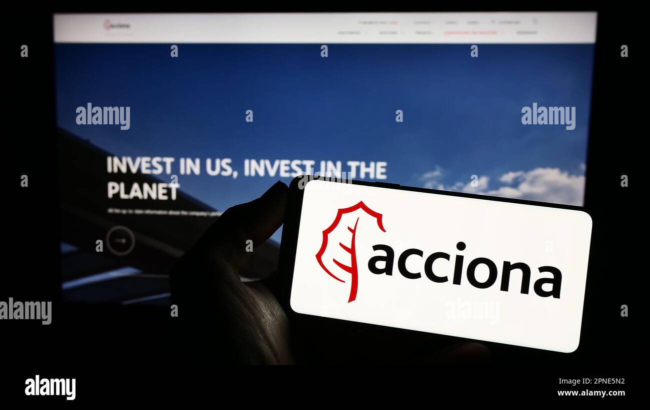 Person holding smartphone with logo of Spanish infrastructure company ...