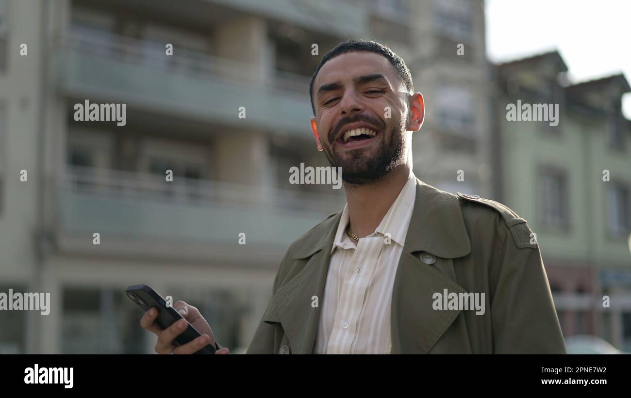 Happy young man laughing and smiling closeup face standing in city ...