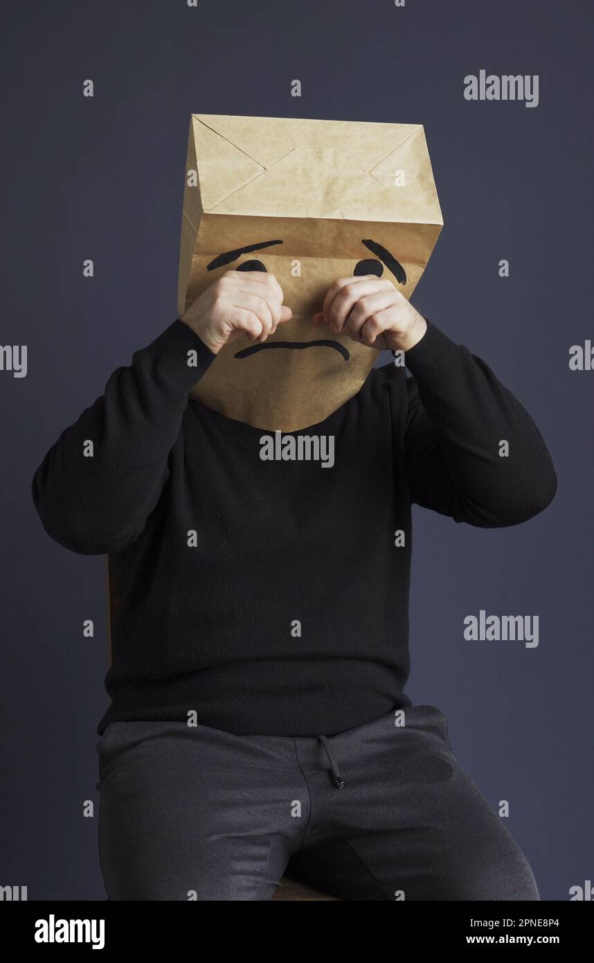 A sad man in a black turtleneck with a bag on his head, with a drawn ...