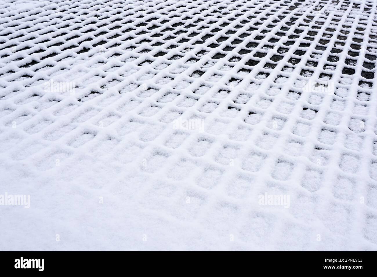 A checkered outline snowy pattern on dark cobblestones, perspective ...