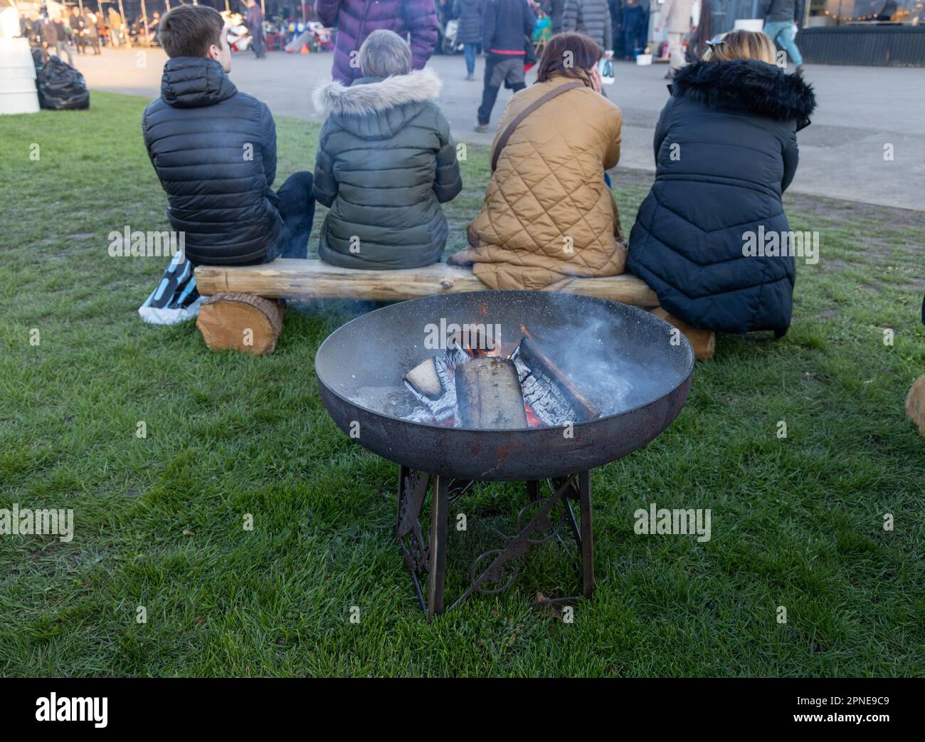 April 2023 - Group of four young women sat with their backs to a fire ...