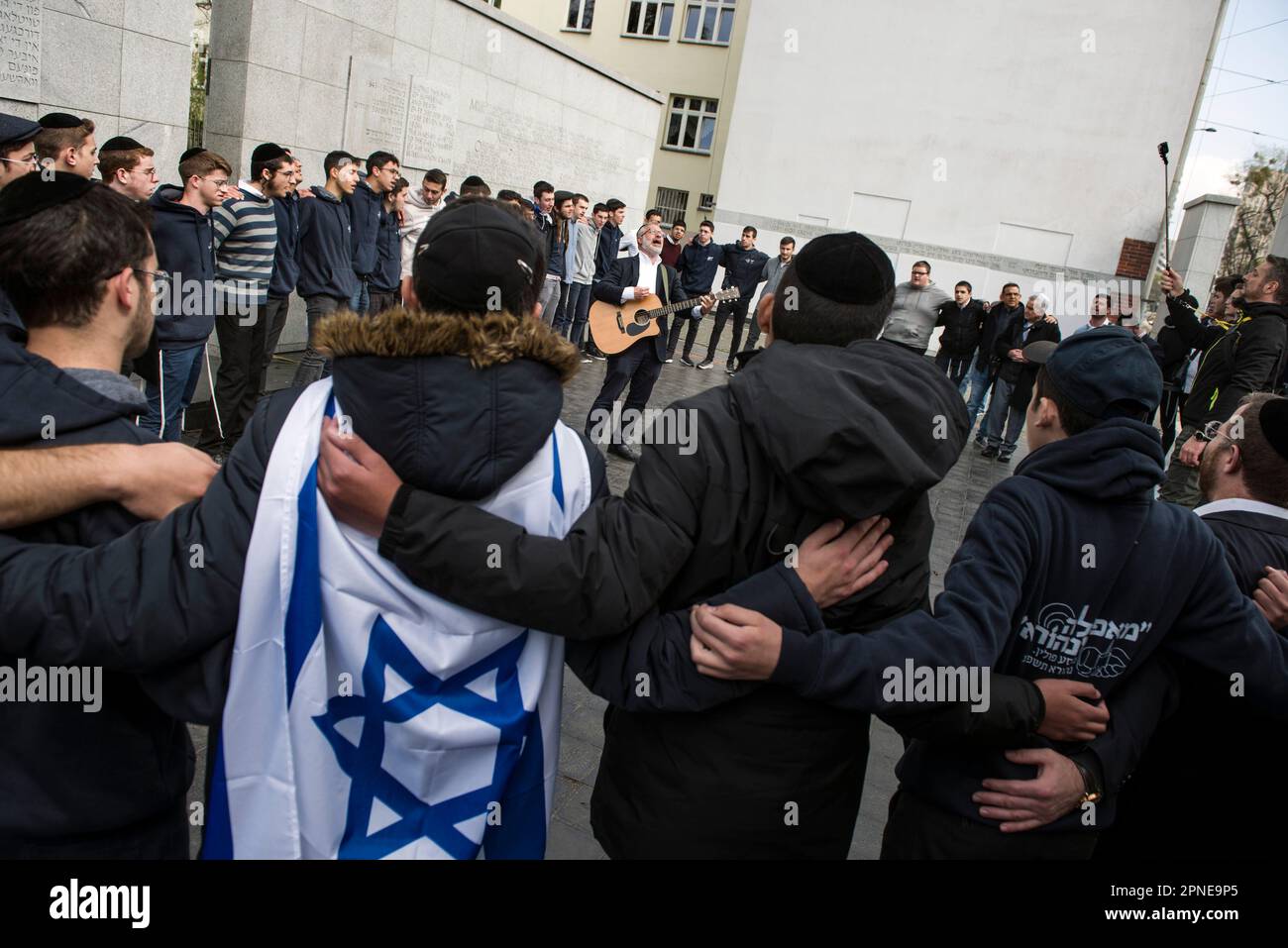 A group of Israeli students sing at the Umschlagplatz Monument Wall ...
