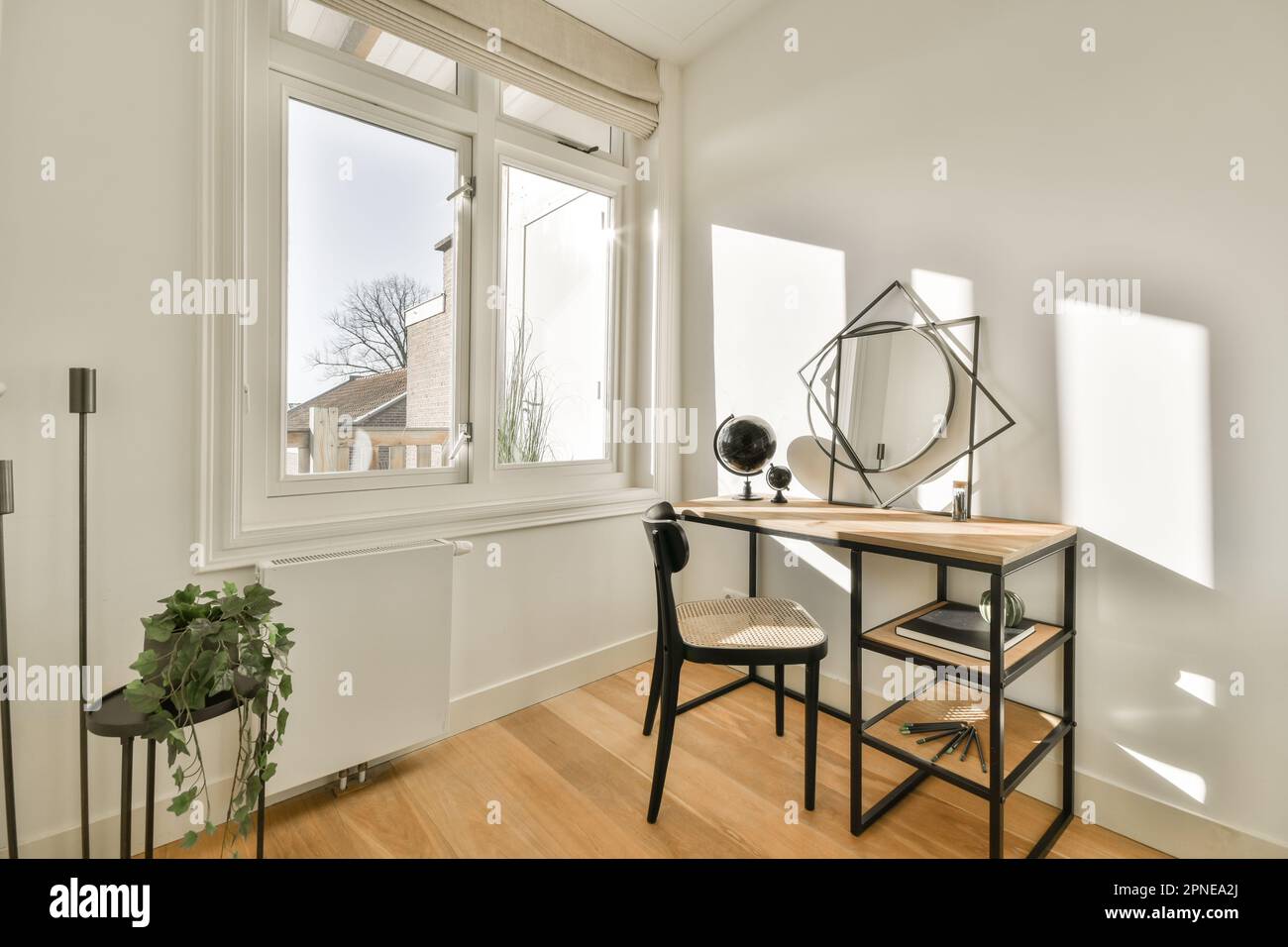 a desk and chair in the corner of a room with a large window looking ...