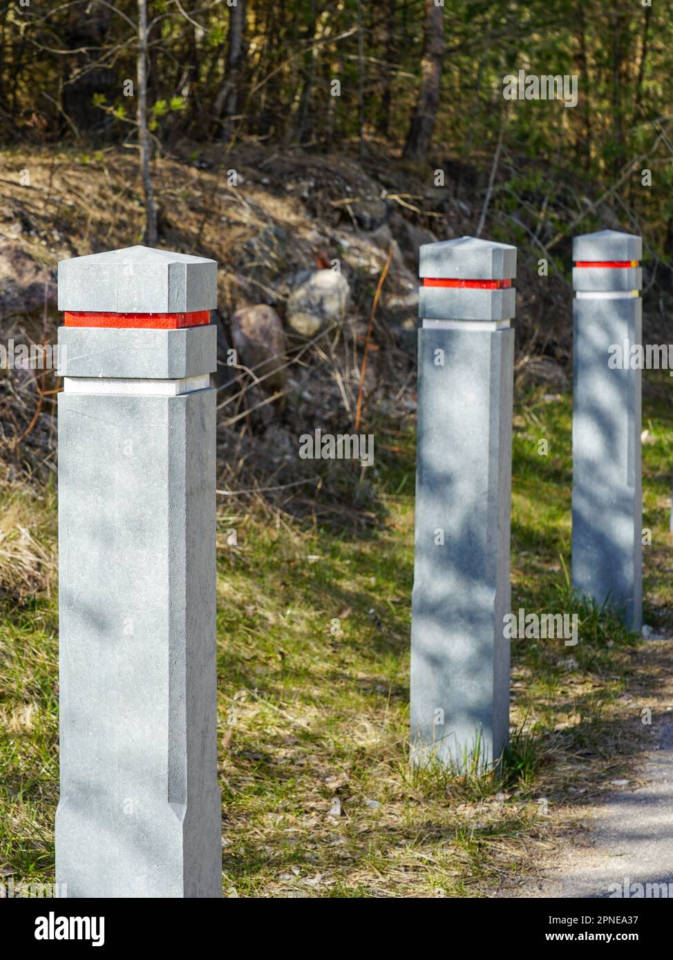 Square gray concrete bollards with red and white reflective tape for ...