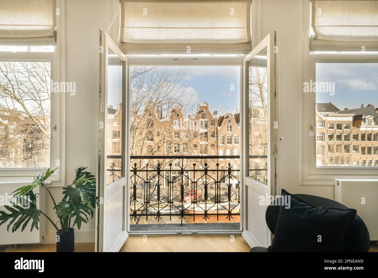 a living room with two windows, and a view of the city from it's front ...