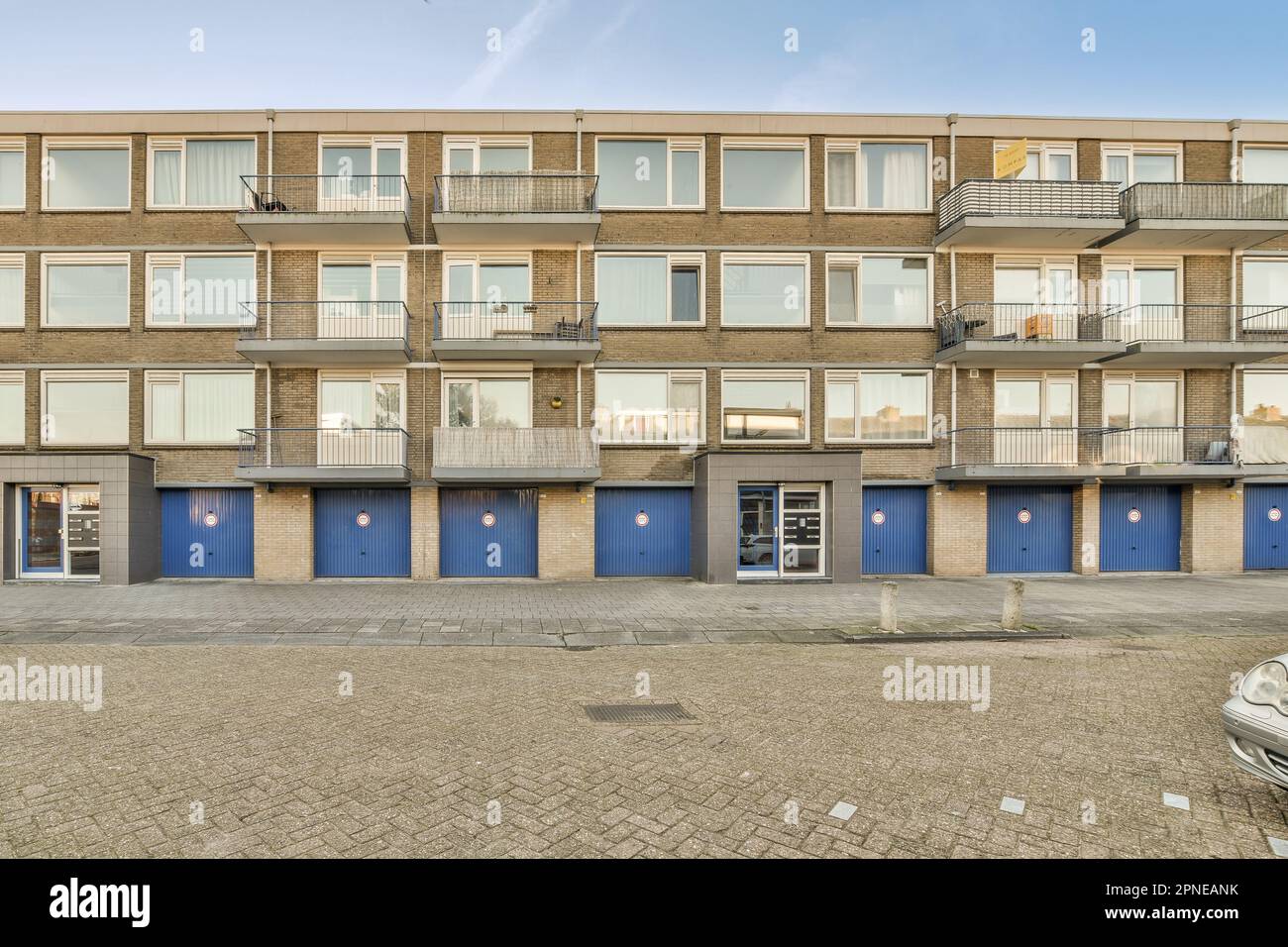 an empty parking area in front of a multi - storey apartment building ...