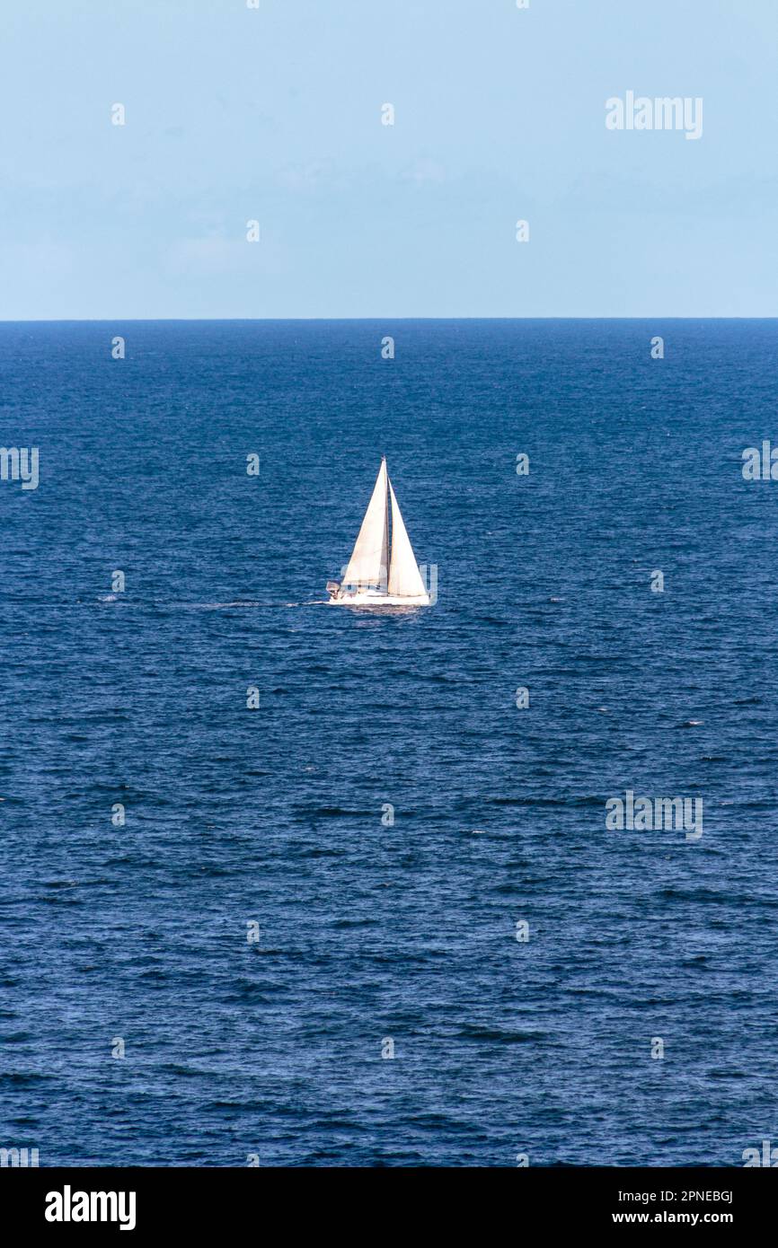 small sailboat in the blue sea of copacabana beach in Rio de Janeiro ...