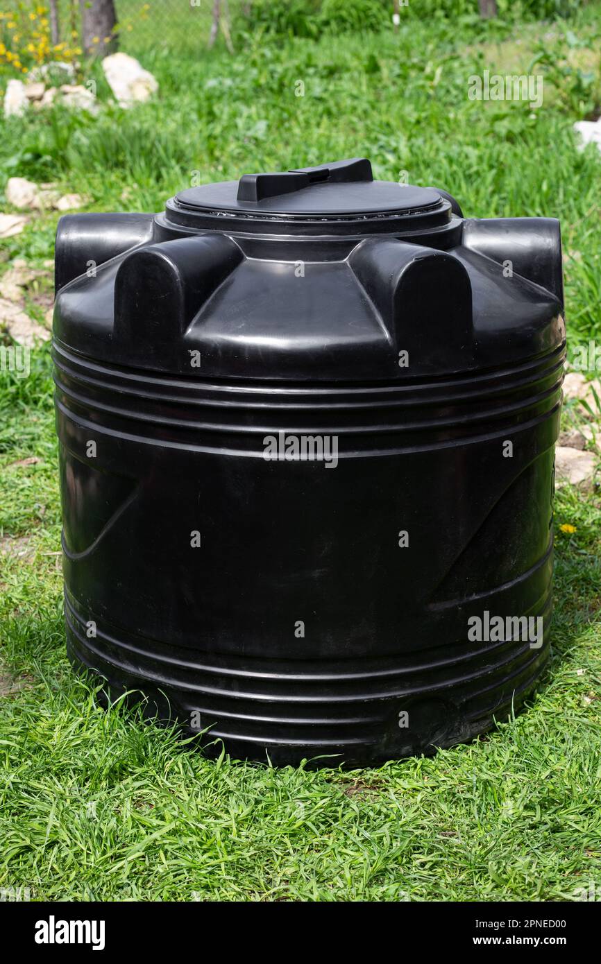 A large plastic black barrel for a summer shower. A container for ...