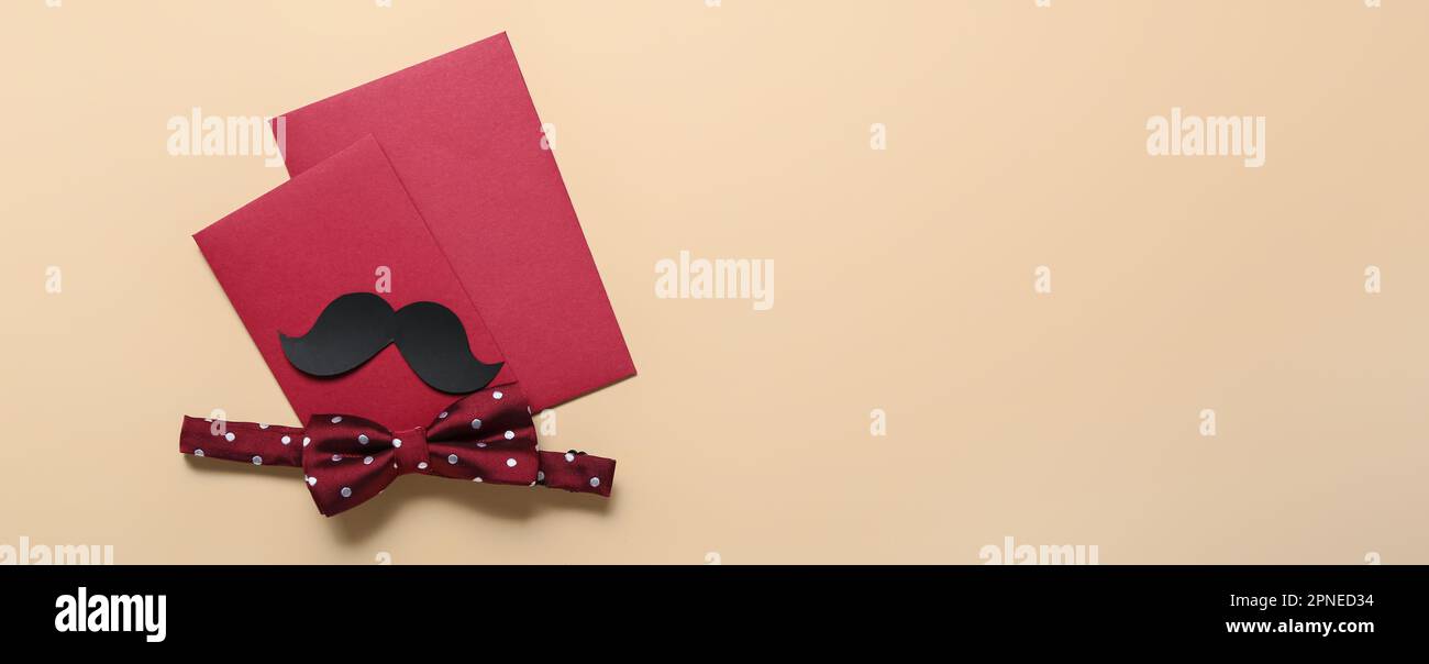 Paper mustache, bowtie and cards on beige background with space for ...