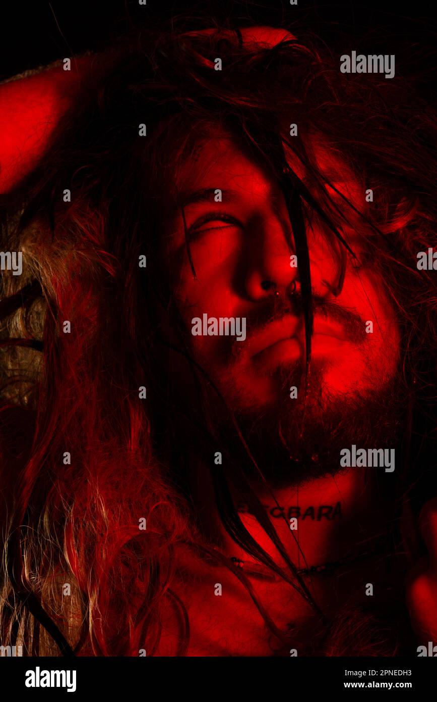Close-up portrait of handsome young man with hair all over his face ...