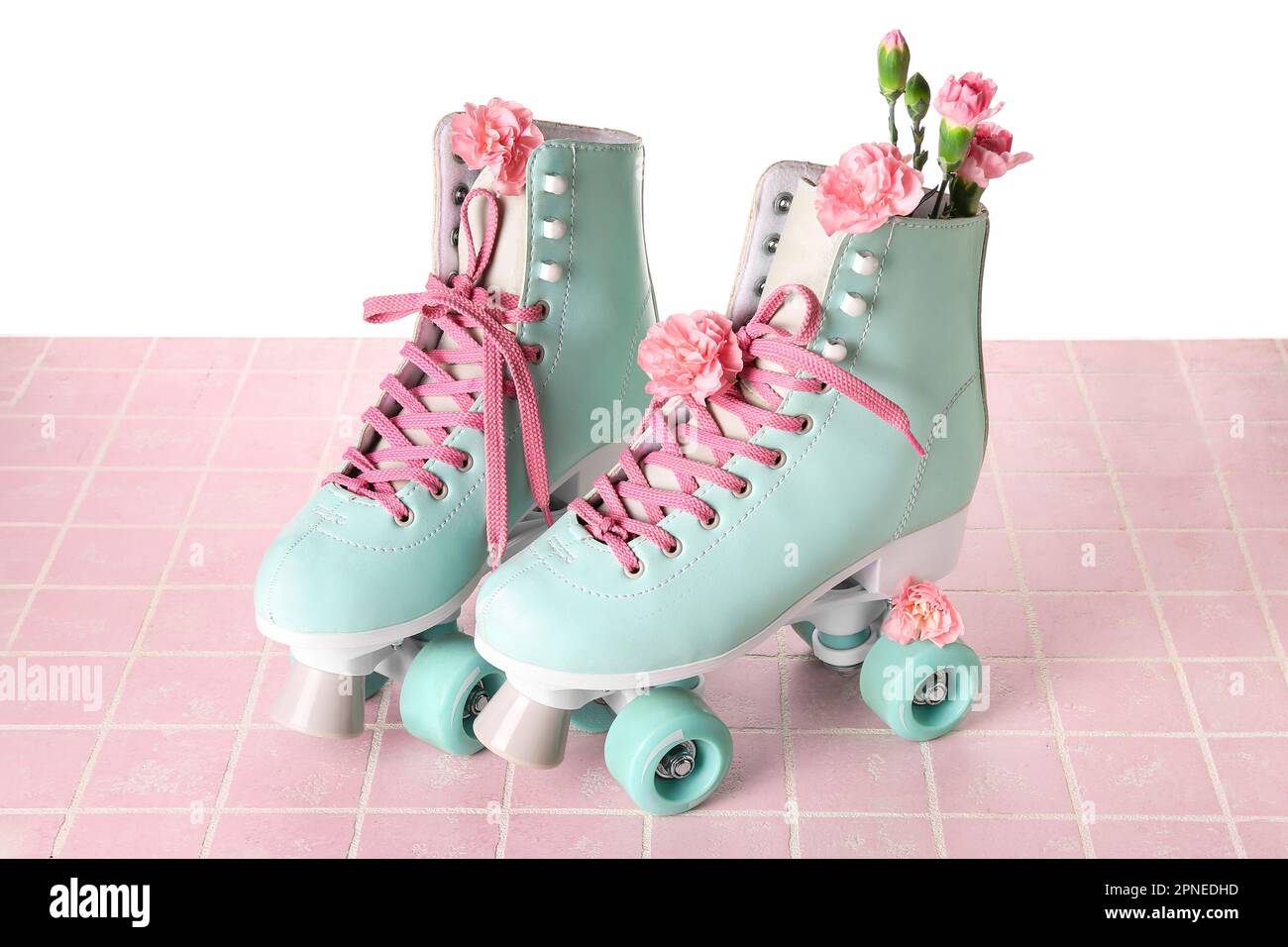 Roller skates with spring flowers on table against white background ...