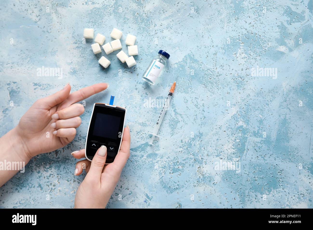 Diabetic woman using digital glucometer on grunge background Stock ...