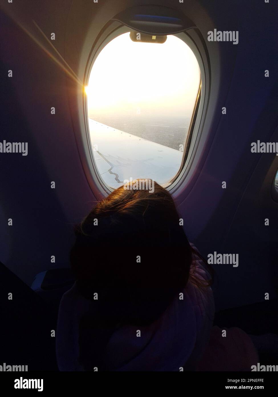 Child enjoy fly on airplane looking on window landscape Stock Photo - Alamy