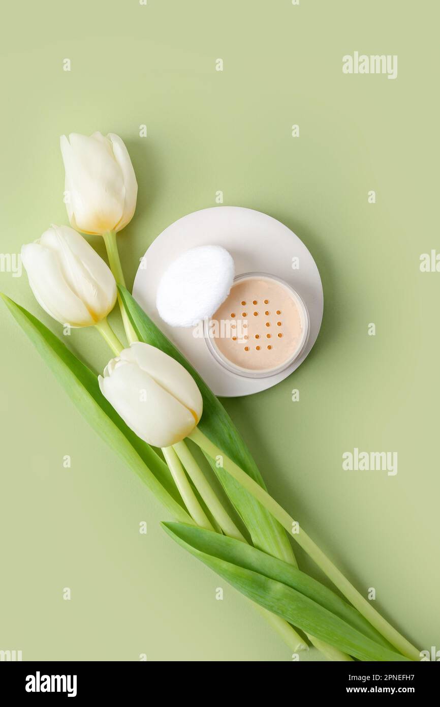 Decorative plaster podium with powder and tulip flowers on green ...