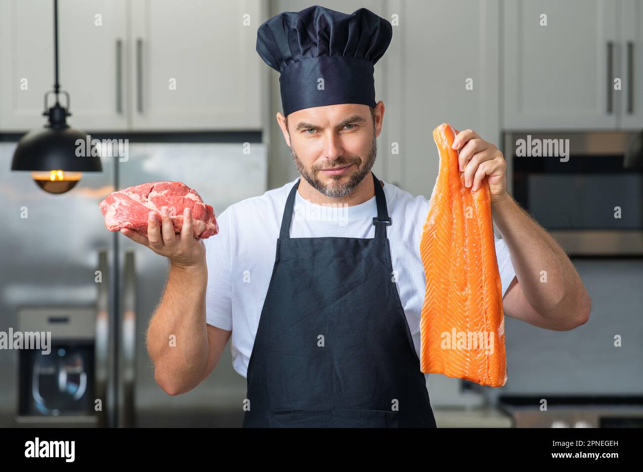 Portrait in kitchen of chef preparing healthy food. Man cooking fish ...