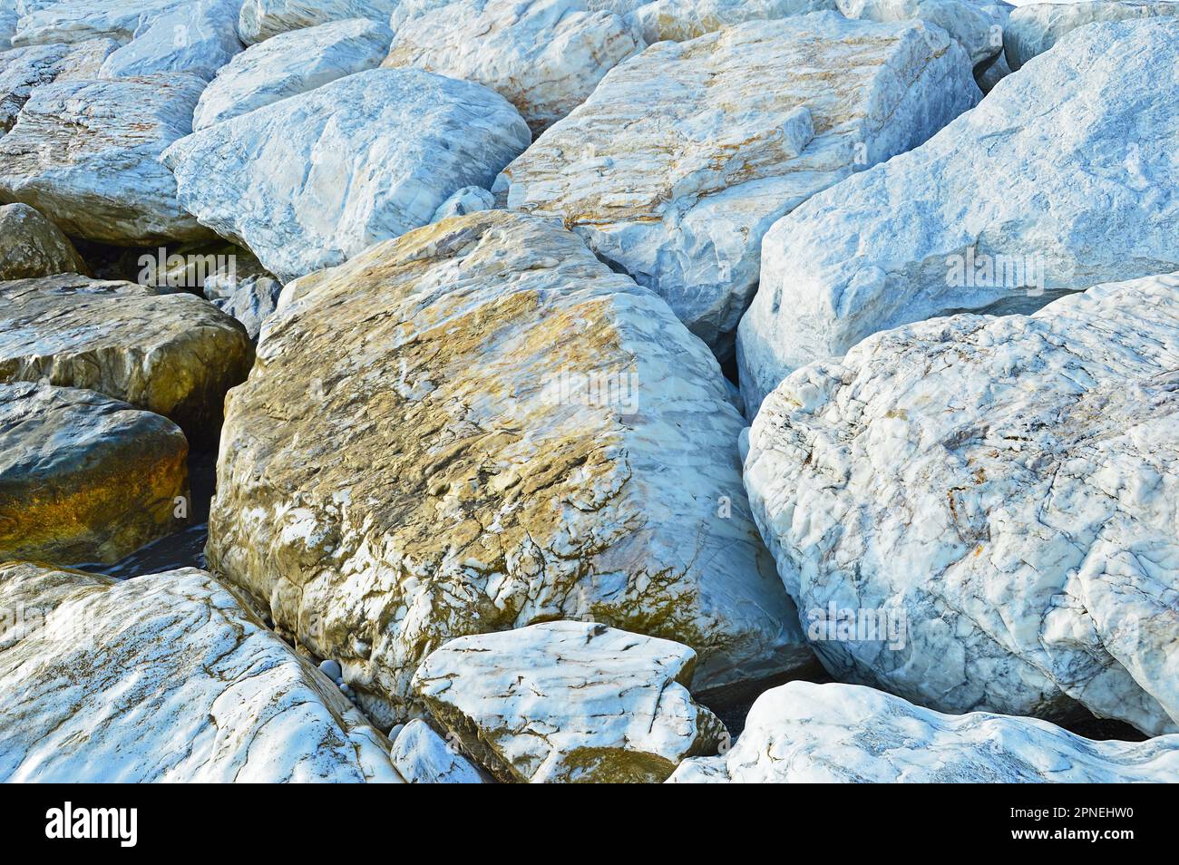 Piles of large marble boulders on the coast Stock Photo - Alamy