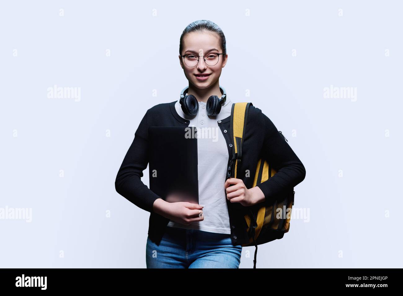 Teenage girl student with backpack holding laptop on white studio ...