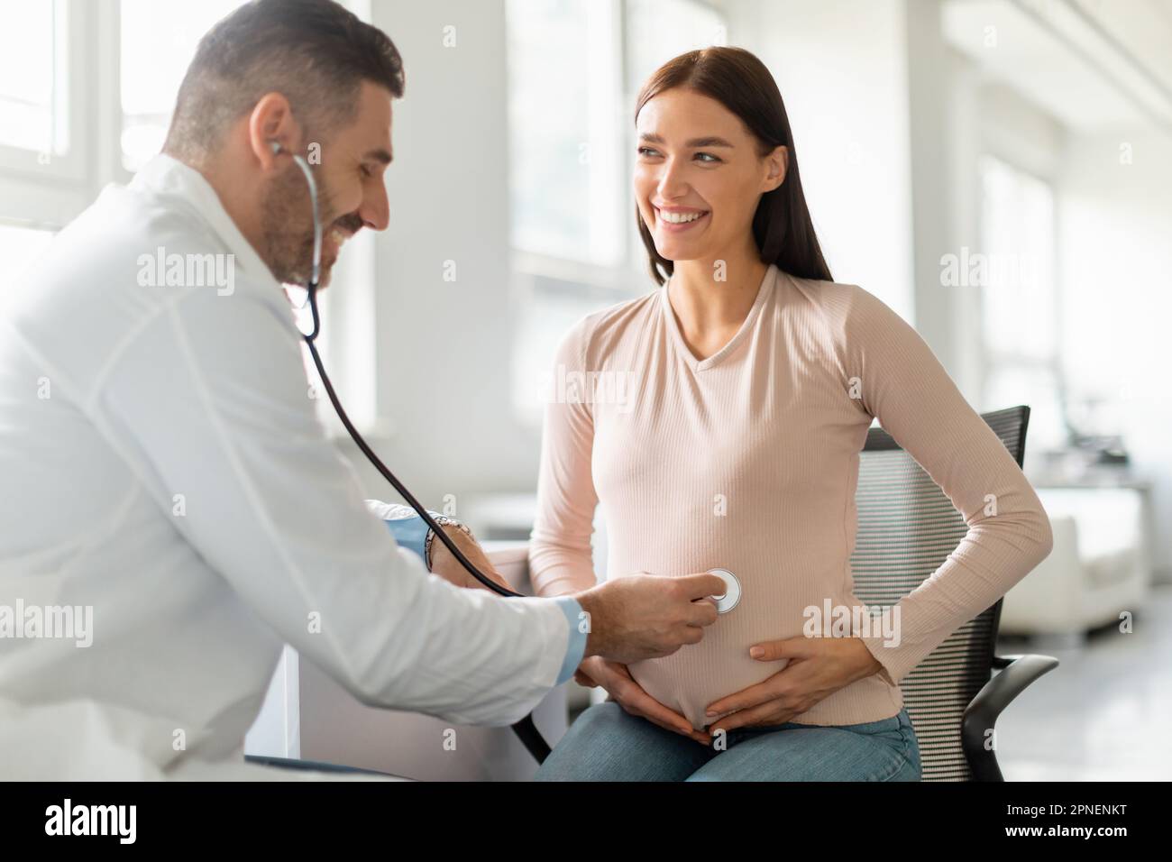 Medical service concept. Male doctor examining pregnant woman's belly ...