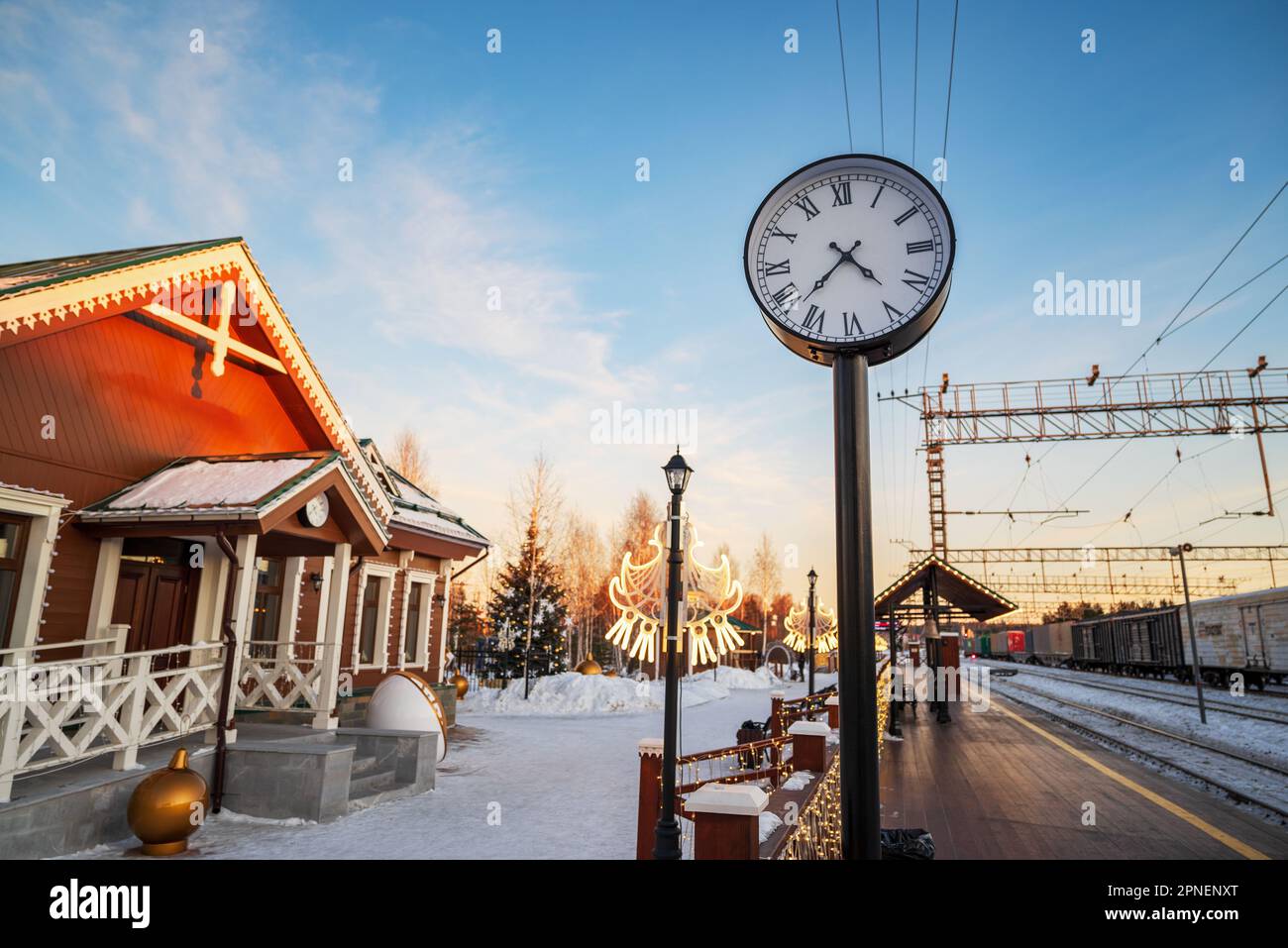 A clock on a post in front of a building with a snowy landscape Stock ...
