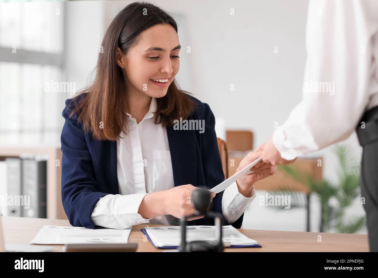 Female accountant working with colleague at table in office Stock Photo ...