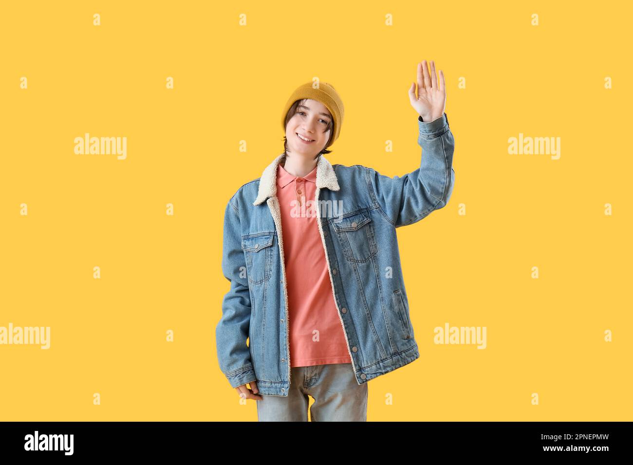 Teenage boy waving hand on yellow background. Hello concept Stock Photo ...