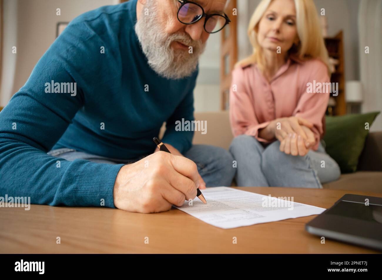 Senior Couple Filling In Form Signing Papers Sitting Indoors Stock ...