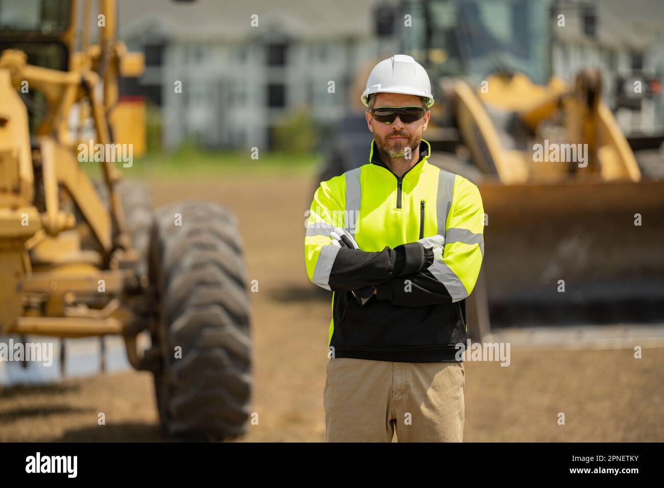 Portrait of builder in a construction site. Builder with excavator ...