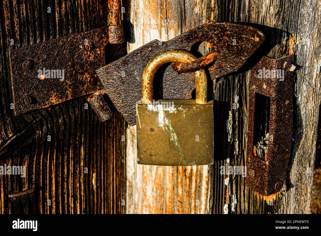 Old rusty lock and padlock on a rotten wooden door Stock Photo - Alamy