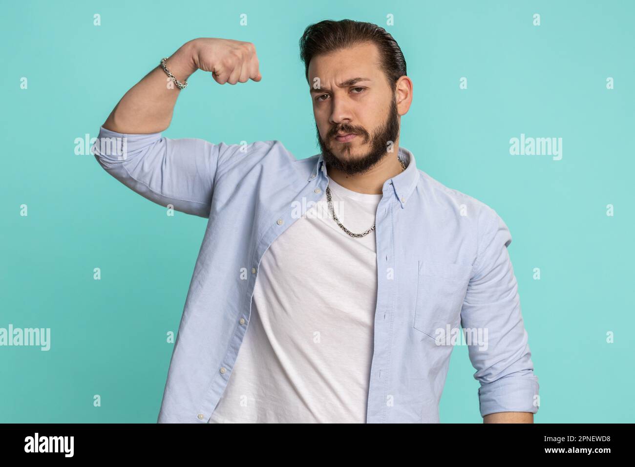 I am strong. Fit sporty lebanese man showing biceps and looking ...