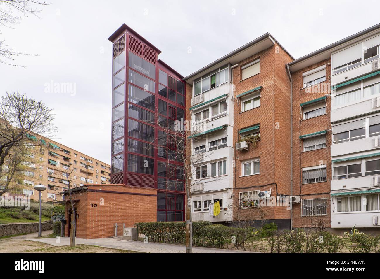 Residential building facades with a red metal elevator annex with ...