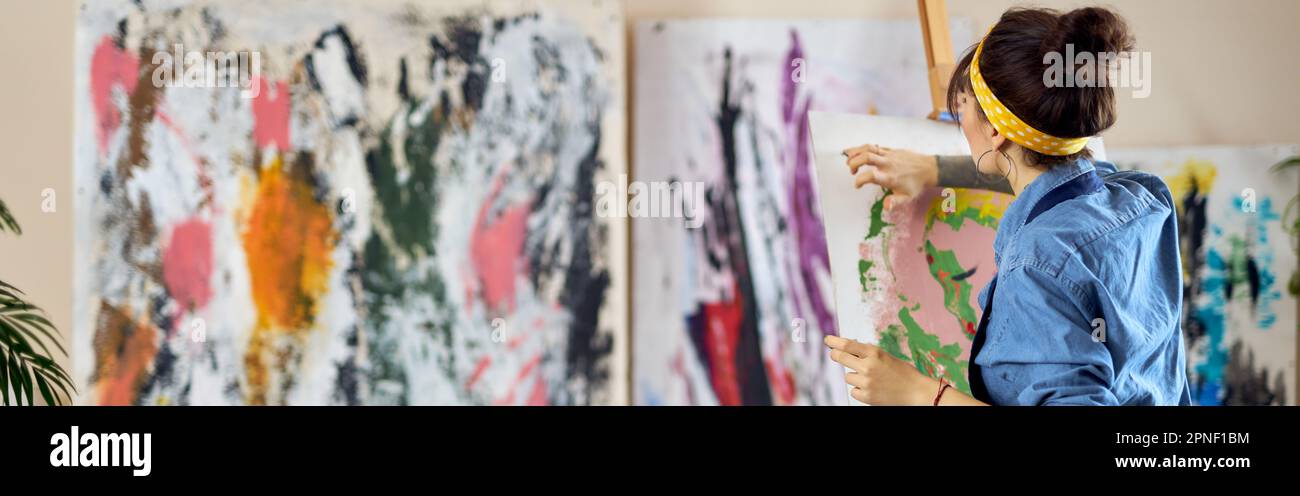 Back view of inspired talented woman, female artist painting at home ...