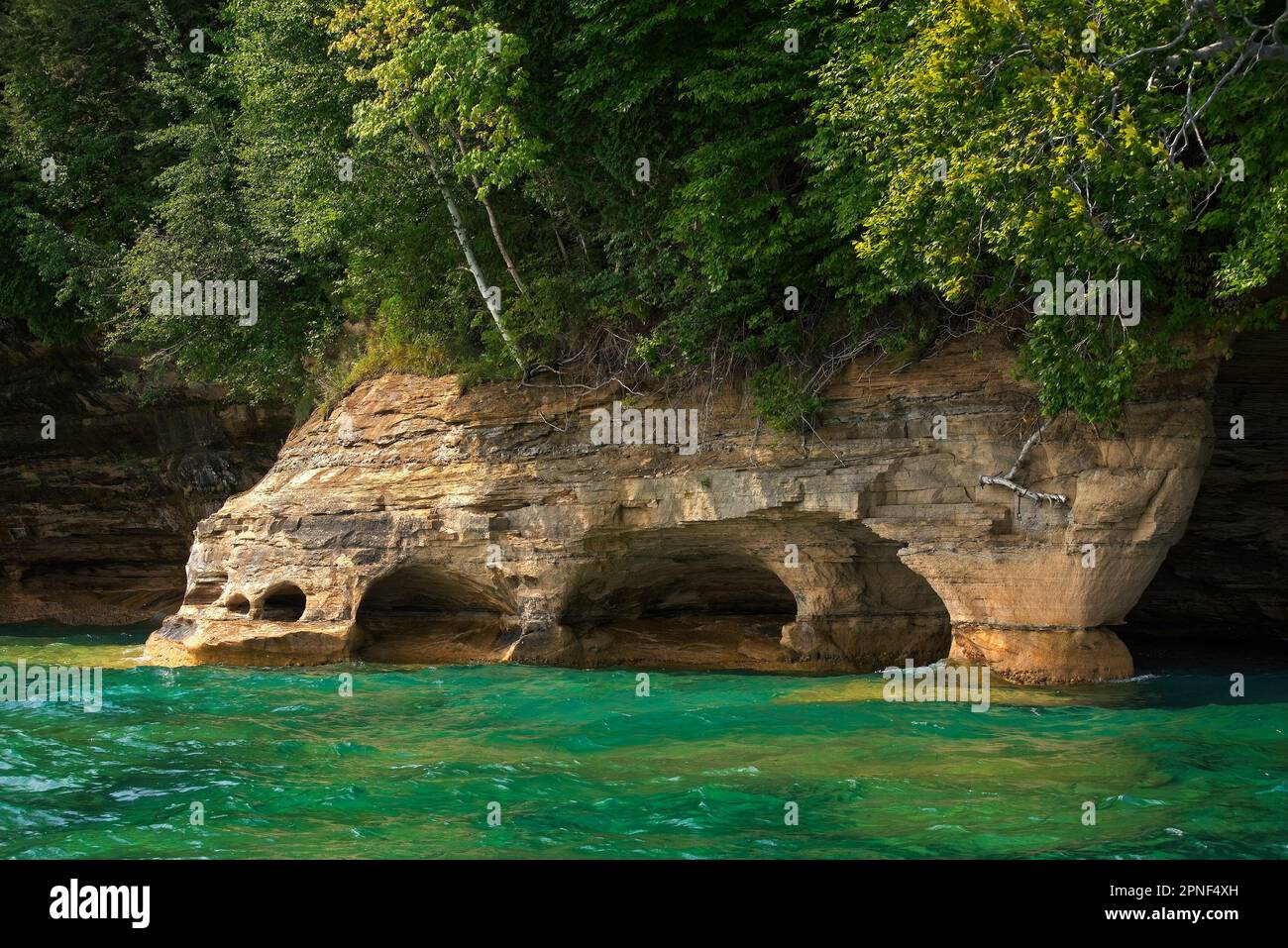 Wave-carved caves at the base of cliffs on Grand Island, Michigan, on ...