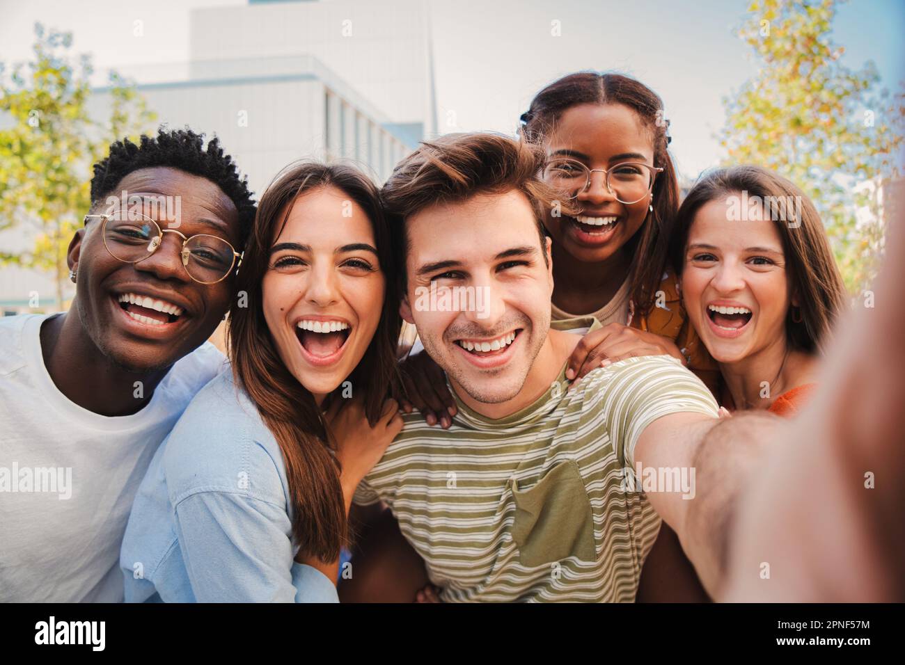 Happy multicultural friends laughing taking a selfie portrait together ...