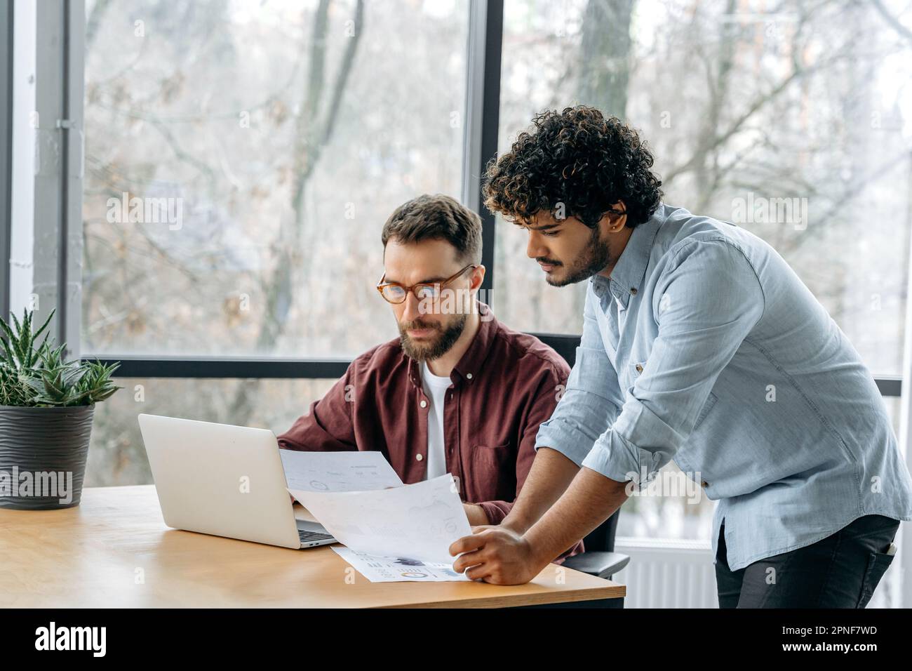 Focused busy successful business colleagues, caucasian man and indian ...