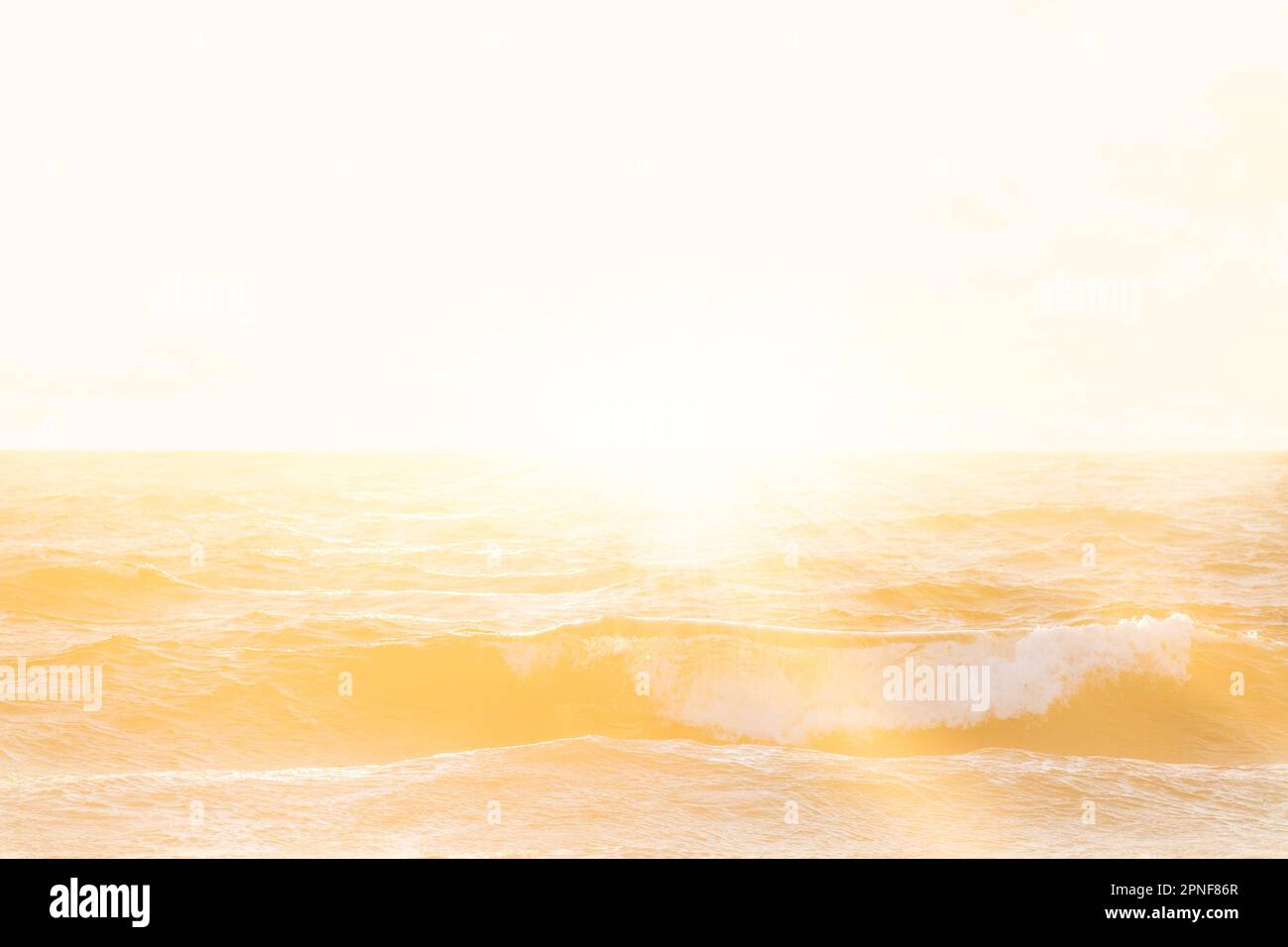 Setting sun shining above ocean Stock Photo - Alamy